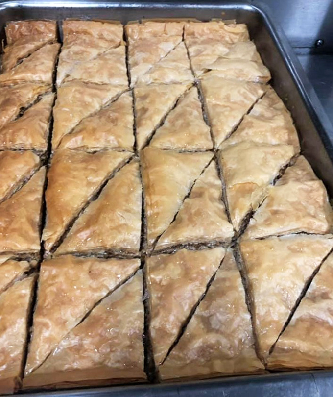 Baklava triangles lined up like delicious dominoes, waiting to shatter into honey-soaked bliss with each perfect bite.