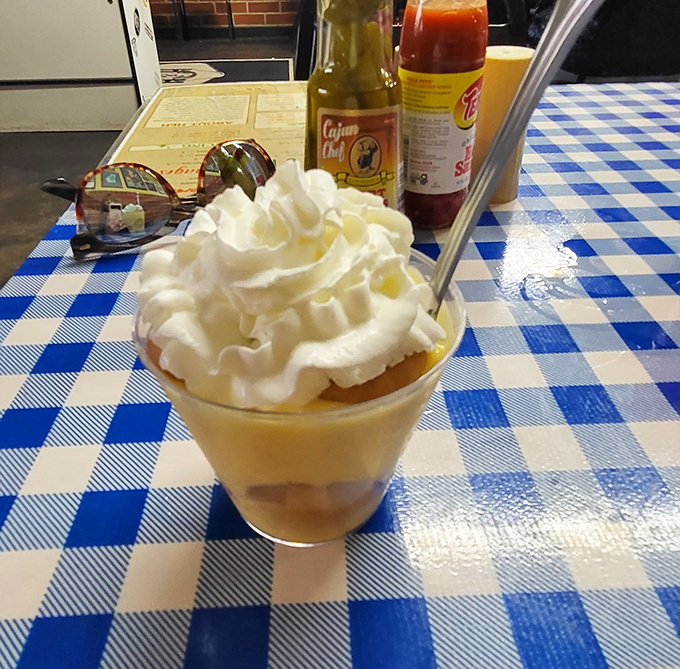 Banana pudding crowned with a cloud of whipped cream&mdash;proof that heaven exists and it's served in a glass on checkered tablecloths.