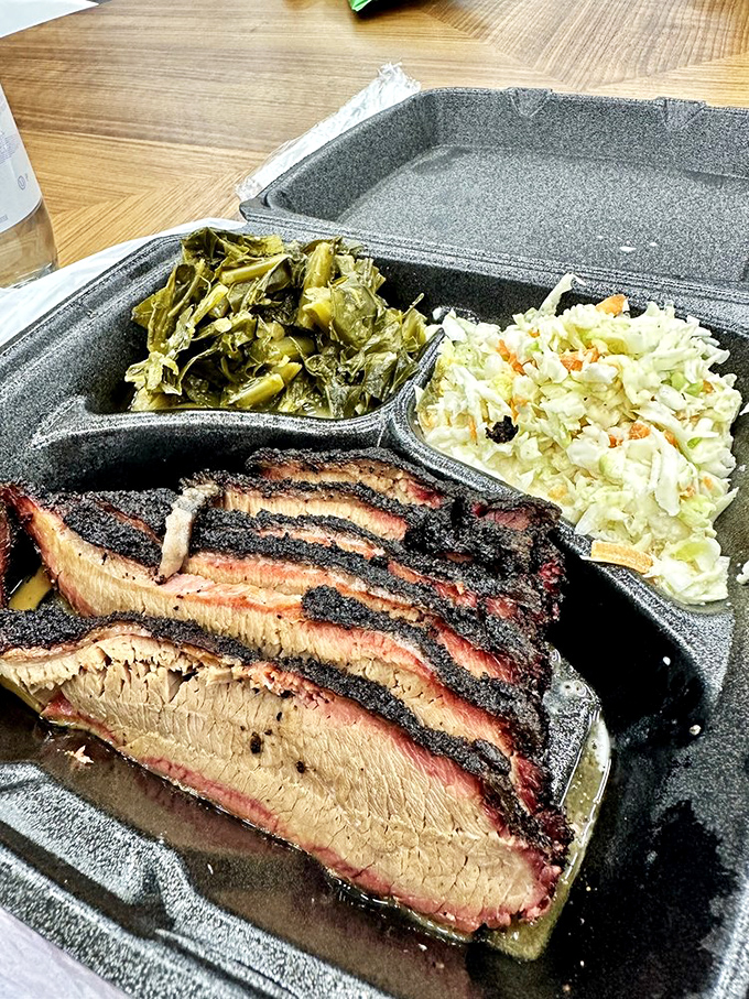 Brisket slices with that perfect pink smoke ring, flanked by collards and coleslaw&mdash;the holy trinity of Southern comfort.