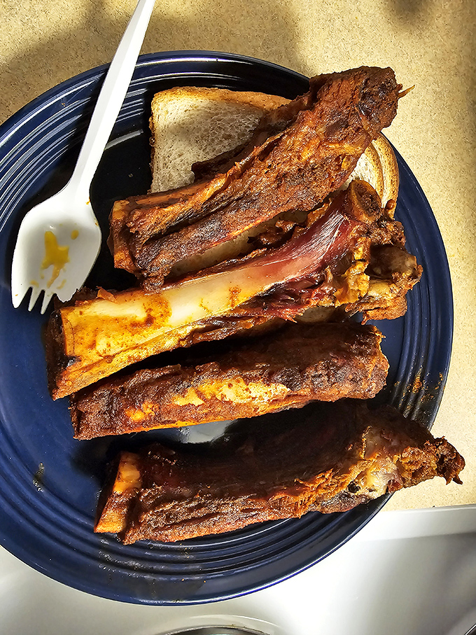 These ribs aren't just falling off the bone &ndash; they're practically volunteering to jump onto your fork. The bread's only purpose? Sauce management.
