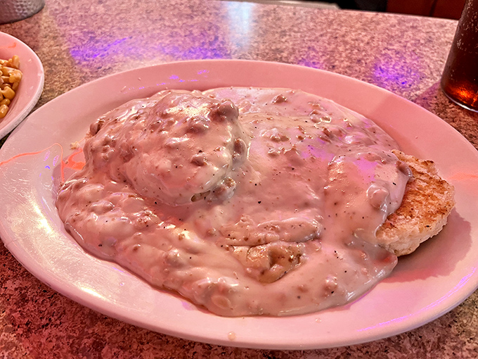 Comfort food incarnate&mdash;a tender biscuit completely smothered in rich, peppery sausage gravy. This isn't just breakfast; it's a warm hug for your taste buds.