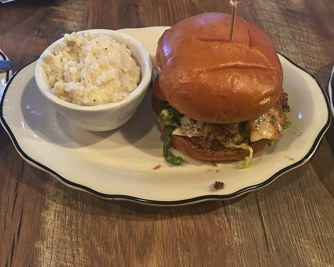 This isn't just a sandwich; it's architecture. A perfectly toasted bun supporting layers of flavor alongside creamy grits that deserve their own fan club.