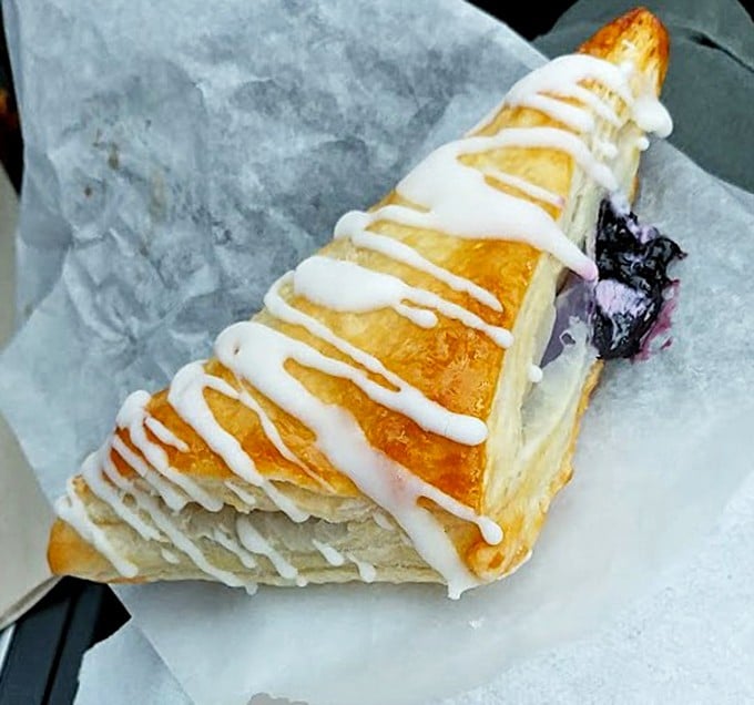 This blueberry turnover isn't just a pastry; it's architecture with purpose. The drizzle of icing is the chef's signature.