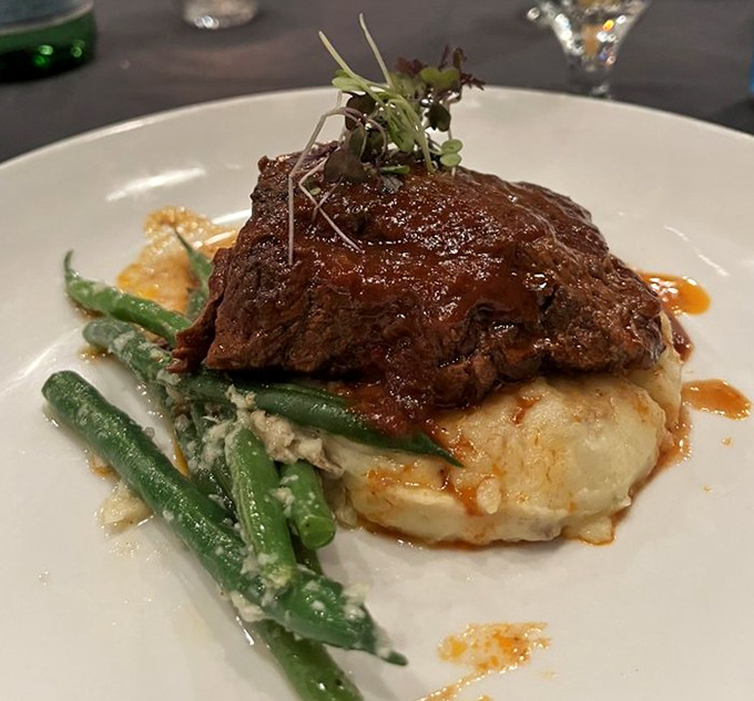 The braised short rib doesn't just fall off the bone – it practically leaps onto your fork, begging to introduce itself to your palate.