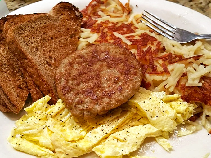 The breakfast trifecta: perfectly scrambled eggs, crispy hash browns, and sausage that would make your cardiologist wince but your taste buds applaud.