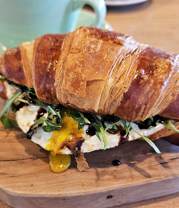 This isn't just a breakfast sandwich—it's morning poetry. Golden croissant, melty egg, and greens combine for a handheld masterpiece.