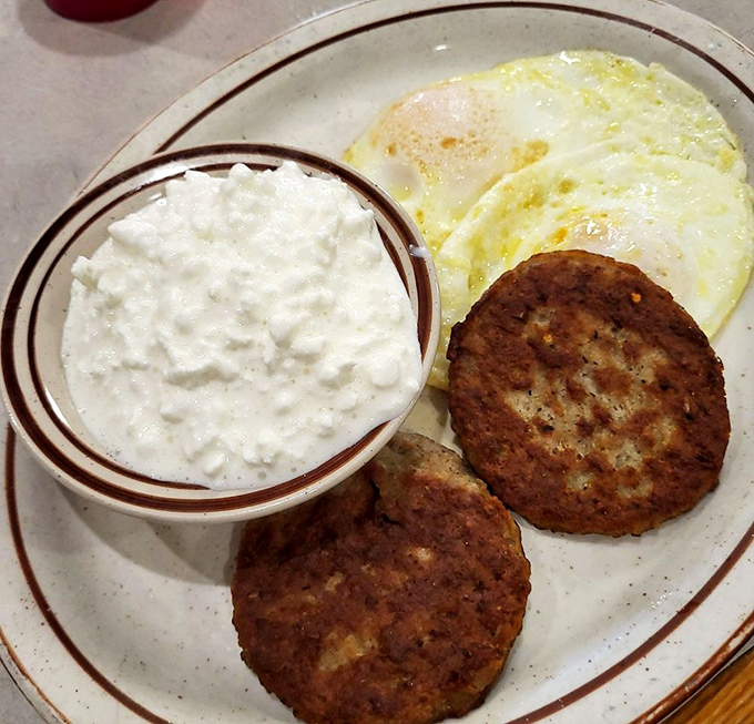 Sausage patties and eggs with a side of cottage cheese&mdash;proof that sometimes the simplest breakfast combinations are life's greatest pleasures.