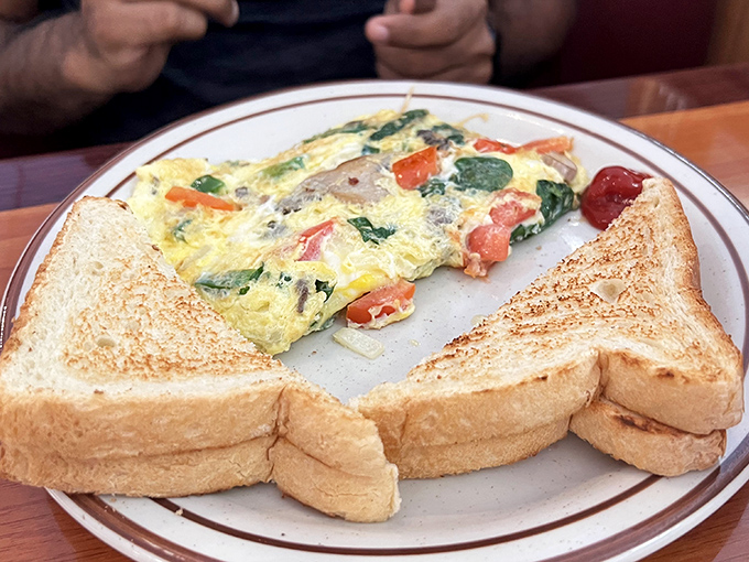 The vegetable omelet that proves vegetables can be more than just a guilt-reducing afterthought. Those perfectly golden toast triangles are non-negotiable.