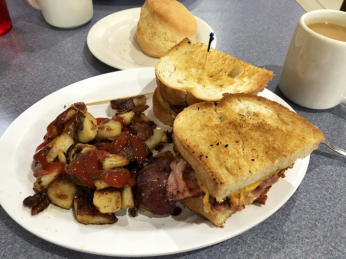 Breakfast sandwich perfection paired with crispy home fries that prove simple ingredients create the greatest masterpieces.