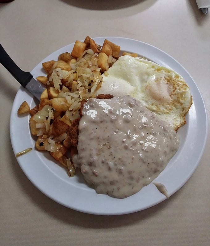 The holy trinity of breakfast: perfectly crispy home fries, eggs with just-right yolks, and gravy that could make cardboard taste good.