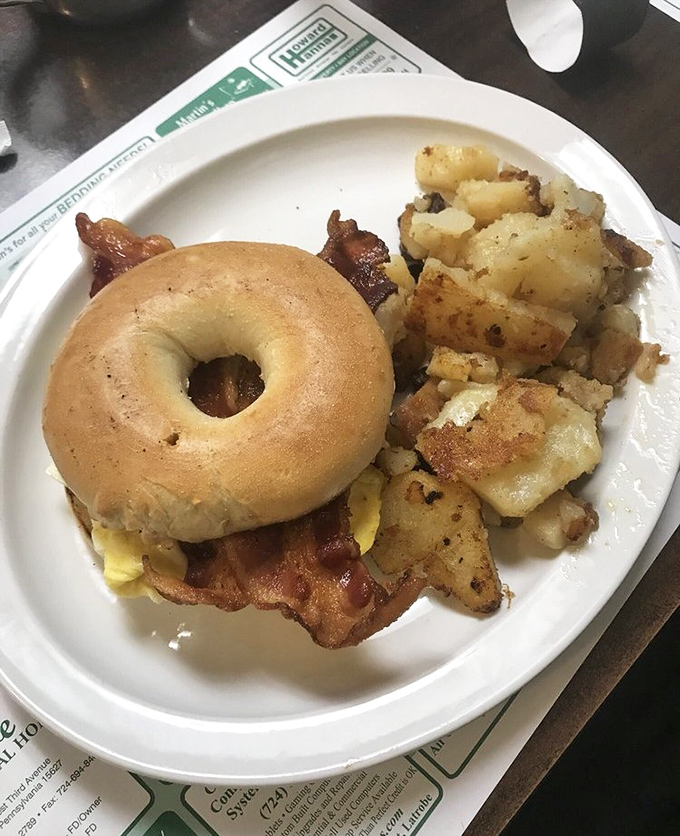 Behold the breakfast sandwich that launches a thousand road trips, perfectly assembled on a toasted bagel with crispy bacon.