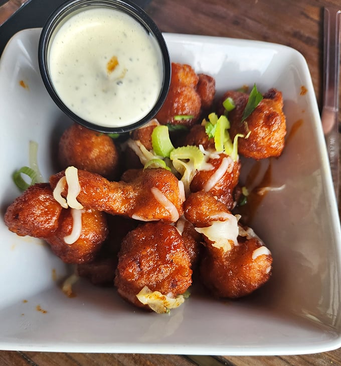 Buffalo fried cauliflower that makes vegetable skeptics reconsider their life choices. The dipping sauce seals the deal.