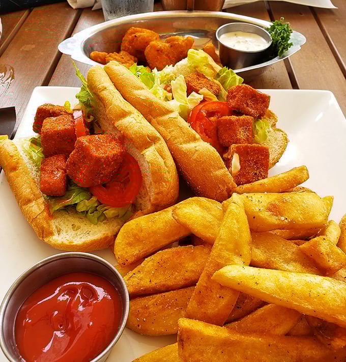 Golden-fried buffalo tofu nestled in a fresh bun with crispy fries&mdash;proof that seafood isn't the only star at this tavern.