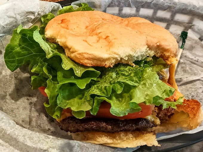Behold the burger in its natural habitat&mdash;simple, unpretentious, and perfectly executed. That fresh lettuce and tomato aren't just garnish; they're the supporting actors that make the beef patty star shine brighter.