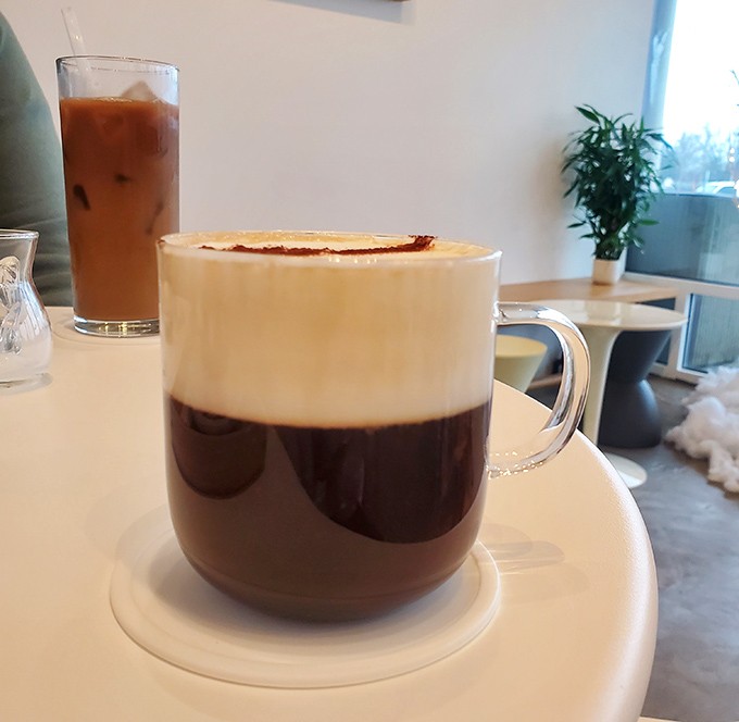 Coffee with a cloud on top! This layered masterpiece proves that sometimes the best things in life come in transparent mugs.