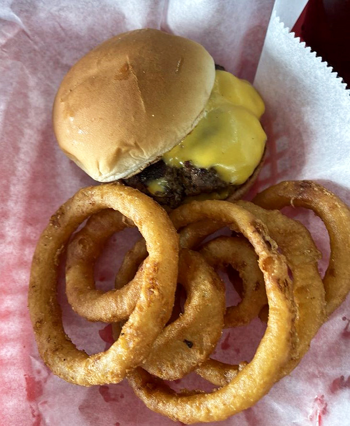 The humble cheeseburger, elevated to art form. Those onion rings aren't just sides&mdash;they're golden halos of crispy perfection.