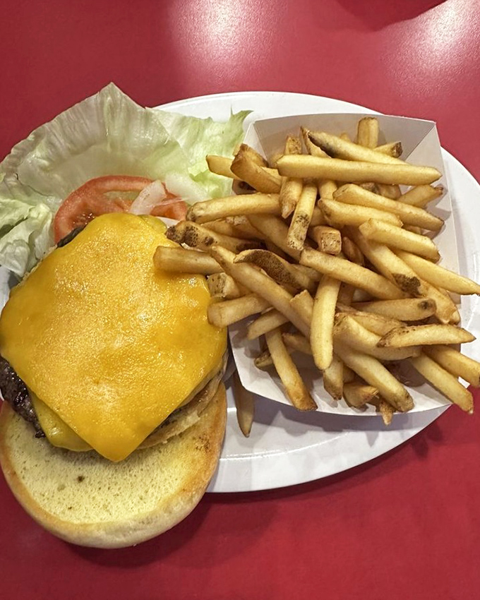 This isn't just a cheeseburger—it's a masterpiece of melty American cheese cascading over a hand-formed patty with a side of golden fry perfection.