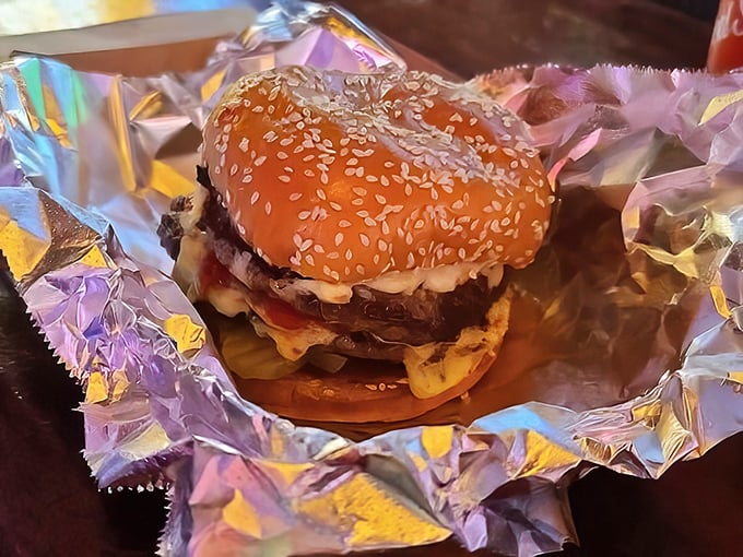 The cheeseburger arrives wrapped like a gift, which it is. Sesame-seeded bun, melty cheese, and beef that reminds you why simple food done right is revolutionary.