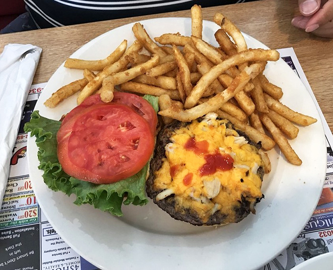 A burger that demands a strategy before the first bite. The melted cheese cascading over the patty is the kind of sight that makes your stomach applaud.