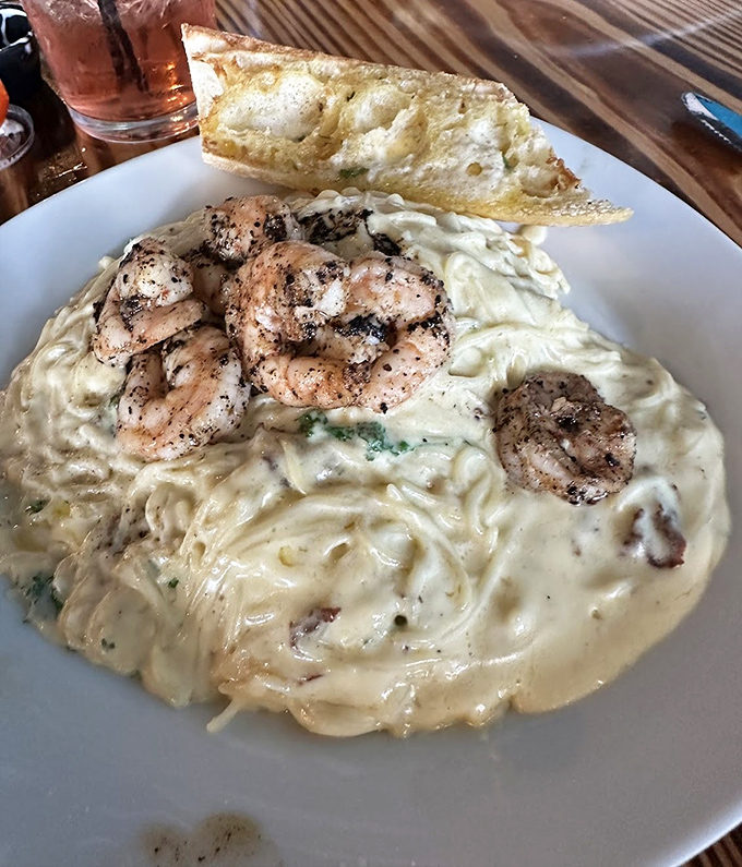 Creamy pasta paradise with perfectly seasoned shrimp. That garlic bread isn't just a side – it's the perfect tool for ensuring not a drop of sauce remains.