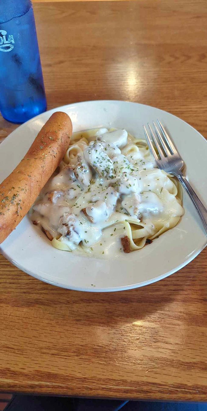 Chicken Alfredo that doesn't skimp on the good stuff&mdash;tender chicken chunks nestled in creamy sauce over wide noodles. That breadstick isn't just a side, it's essential equipment.