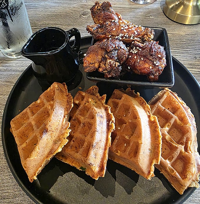 Chicken and waffles: the breakfast-dinner hybrid that proves some of the best relationships are unexpected. That syrup pitcher is basically liquid happiness.