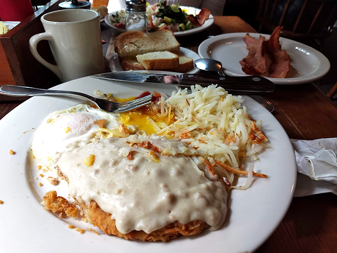 Behold the star of our show: chicken fried steak swimming in peppery gravy with golden hash browns standing guard. Breakfast nirvana achieved on a single plate.