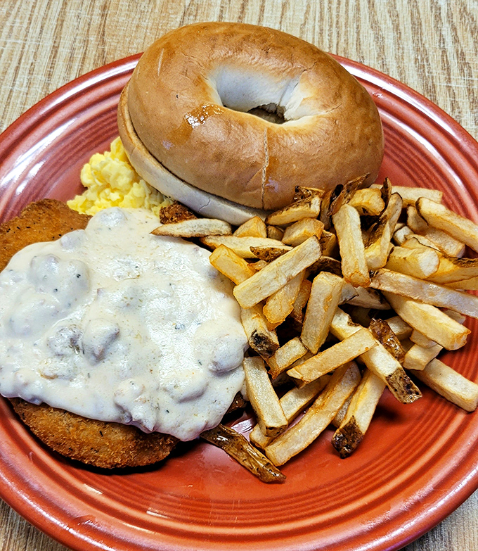 Comfort food personified: A golden biscuit smothered in creamy gravy alongside crispy fries. The kind of breakfast that fuels both body and soul.