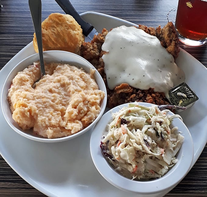 Country-fried comfort topped with creamy gravy alongside cheesy grits and homemade slaw. This isn't just a meal—it's a Southern hug on a plate.