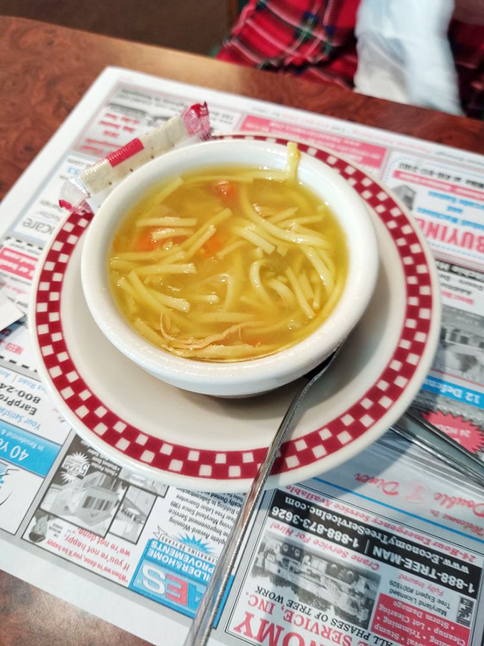 Chicken noodle soup that could cure anything from a cold to a broken heart, served with the obligatory diner newspaper backdrop.