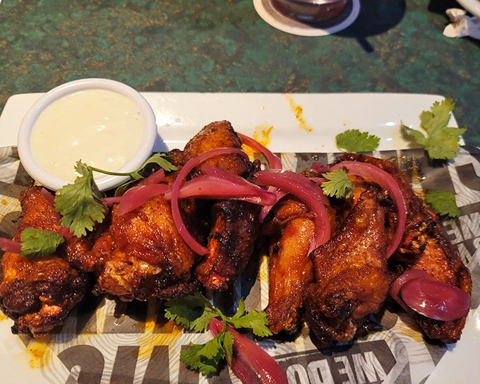 These wings aren't just smoked, they're having a flavor party with pickled onions and fresh cilantro &ndash; proof that barbecue joints can be surprisingly sophisticated when they want to be.