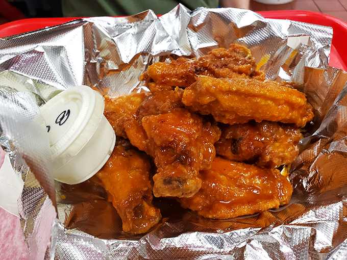 These wings aren't just fried&mdash;they're transformed. Glistening with sauce and nestled in foil like the culinary treasures they are. Napkins: mandatory. 