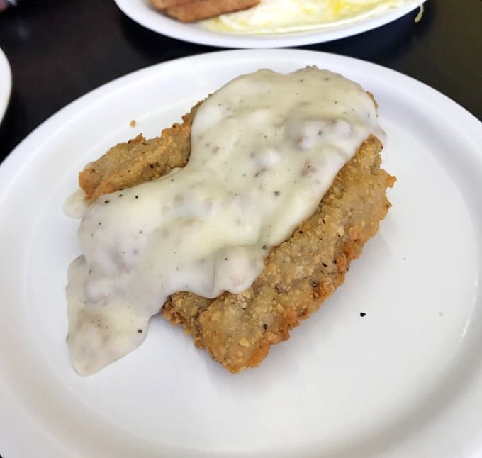 This chicken fried steak swimming in creamy gravy isn't just breakfast&mdash;it's therapy on a plate, offering comfort that no therapist's couch could match.