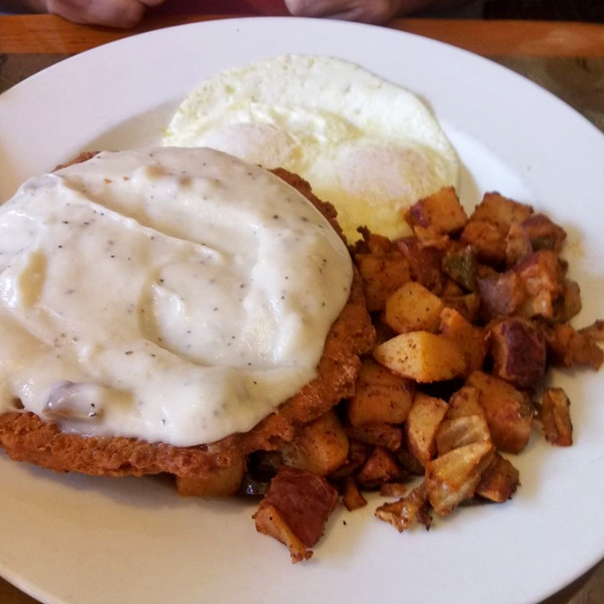 Behold the crown jewel: country-fried steak smothered in peppery gravy alongside crispy home fries. Comfort food that hugs your soul.