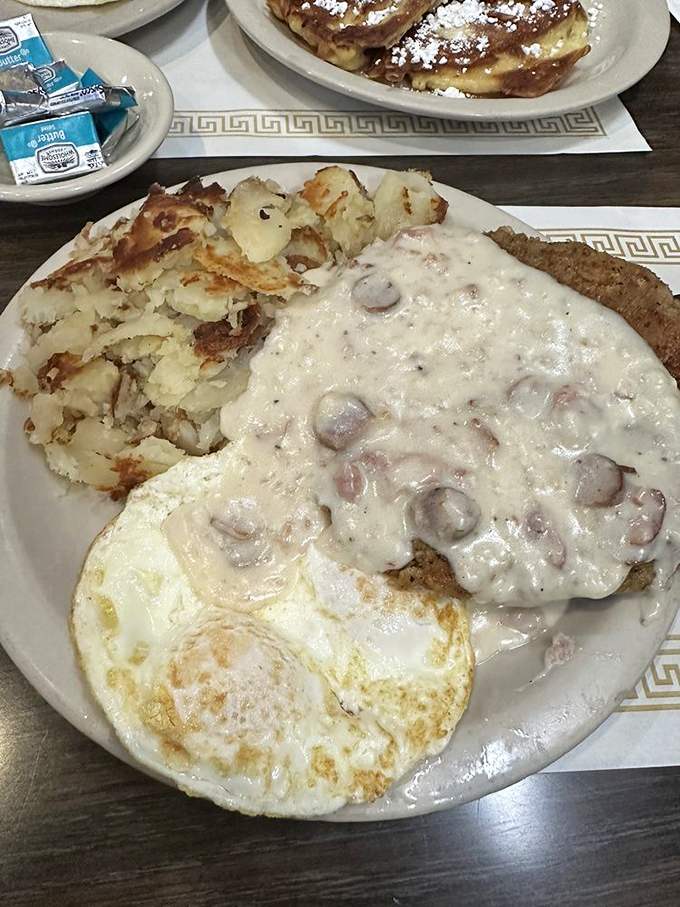 Country gravy cascading over chicken fried steak with those legendary potatoes&mdash;a plate that says "you won't need lunch" in the most delicious way possible.