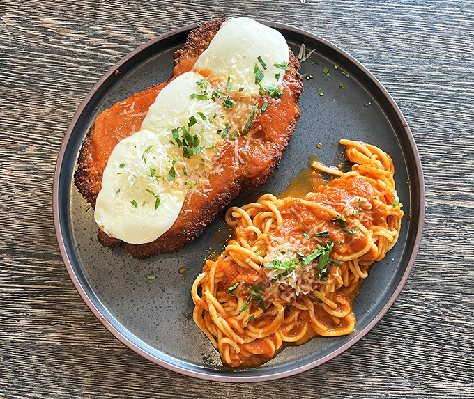 The chicken parm comes with a side of perfectly cooked pasta, creating the kind of plate that makes you want to cancel all afternoon appointments.