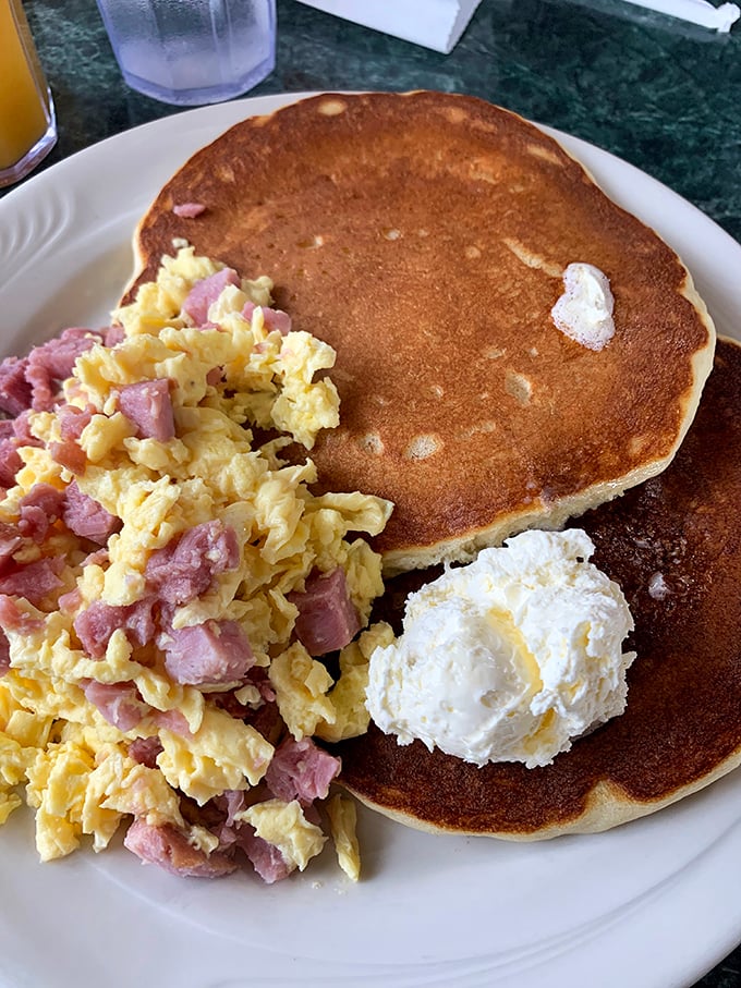 Ham and eggs: the Fred Astaire and Ginger Rogers of breakfast, dancing together on a plate with a pancake backdrop.