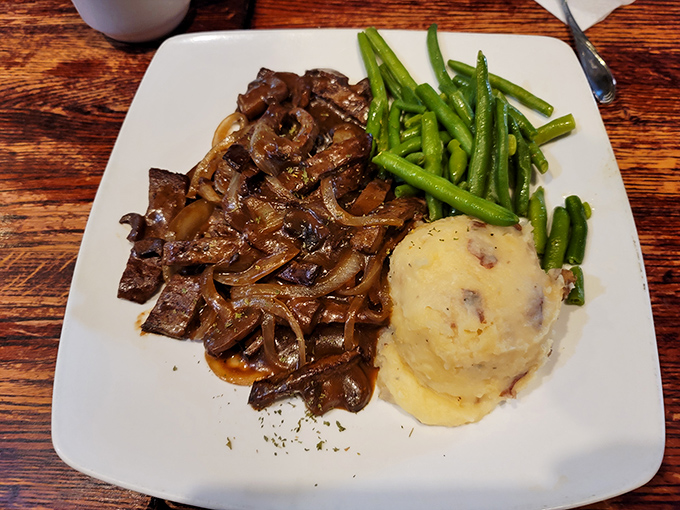 The legendary chopped steak&mdash;tender beef smothered in savory gravy and caramelized onions&mdash;proves that simple food done right is culinary poetry.