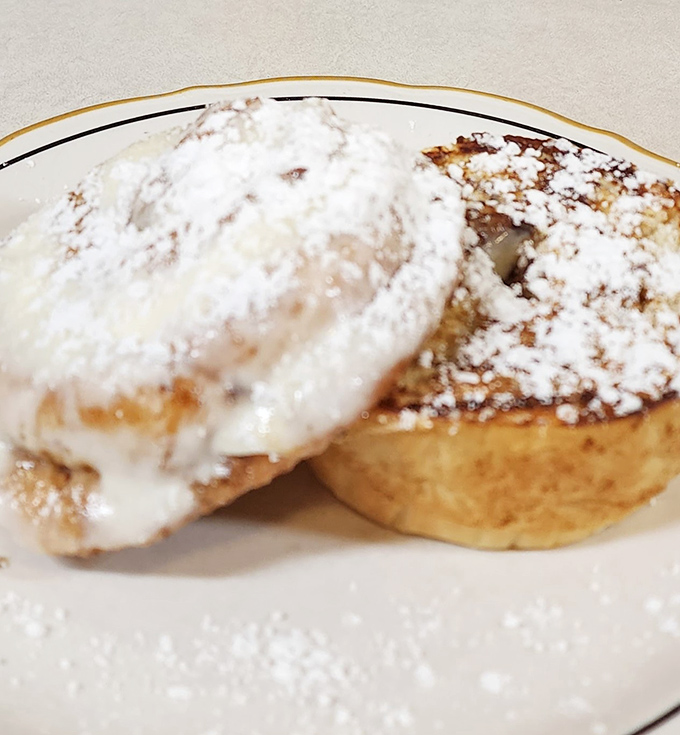 These cinnamon rolls aren't just dessert, they're an architectural achievement—layers of pastry crowned with a snowfall of powdered sugar that would make even the most disciplined dieter weak-kneed.