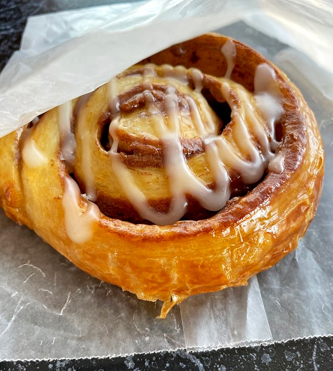 Cinnamon roll perfection: golden, swirled, and glazed with that sweet icing that makes Monday mornings bearable again.