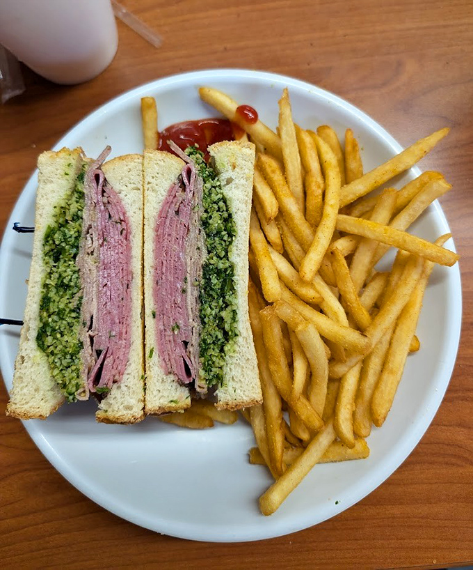 A proper deli sandwich should require both hands and your full attention. This roast beef creation, with its vibrant green pesto, demands nothing less.