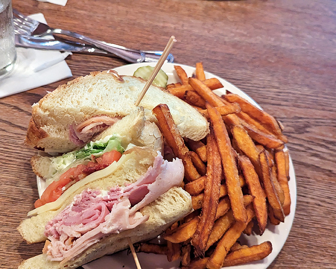 A proper club sandwich that stands tall and proud, with sweet potato fries that could make a cardiologist temporarily suspend their medical advice.
