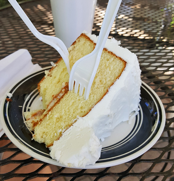 A slice of coconut cake so pristine it deserves its own display case at the Louvre—or at least its own moment of reverent silence.