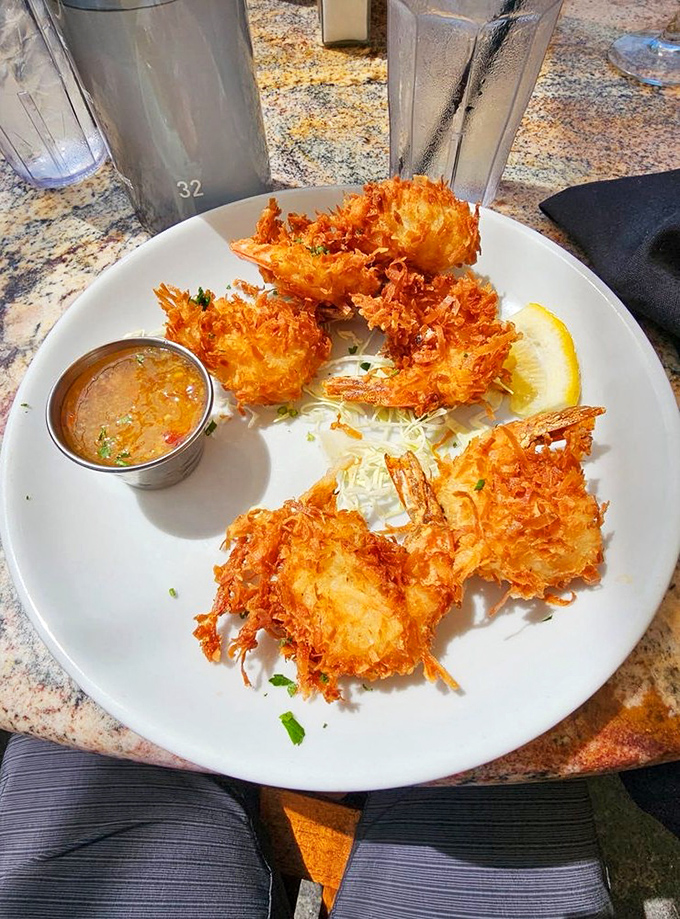 These coconut shrimp aren't just fried, they're transformed—crispy, golden halos of sweetness surrounding plump treasures from the sea.