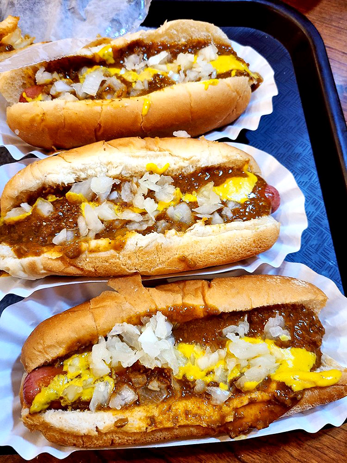 The holy trinity of Michigan dining: perfectly steamed buns, snappy dogs, and that signature coney sauce topped with mustard and onions. Poetry on a paper liner.