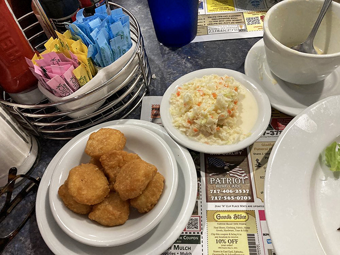 Golden corn fritters that crunch like autumn leaves, paired with creamy coleslaw. Simple pleasures that remind you why diners endure.