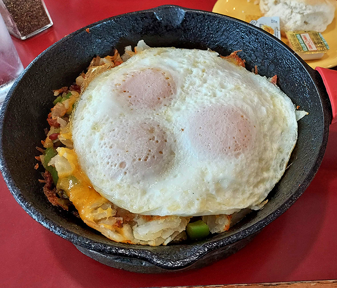 The Country Skillet arrives sizzling hot, with sunny-side-up eggs crowning a kingdom of potatoes, peppers, and melted cheese. Morning royalty has arrived!