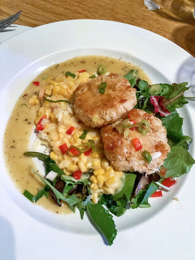 
These crabcakes aren't just sitting on creamed corn&mdash;they're holding court, surrounded by their loyal subjects of microgreens and red pepper confetti. 