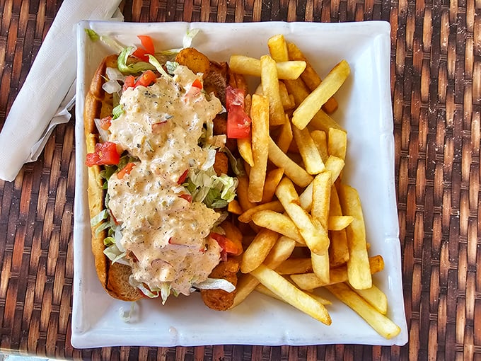 The crab po' boy arrives like a delicious architectural challenge&mdash;how to fit that mountain of seafood and slaw into your mouth without wearing half of it home.