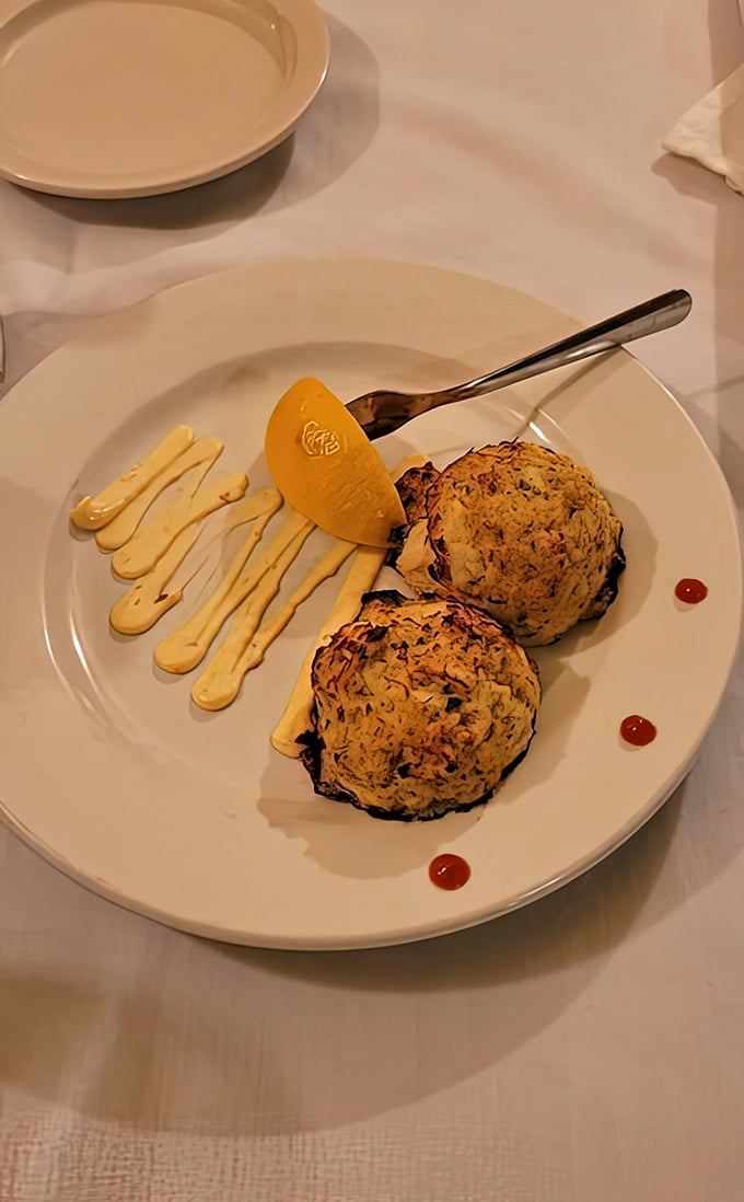 Artfully plated crab cakes with decorative sauce flourishes &ndash; because in Wisconsin, even bar food deserves a touch of elegance.